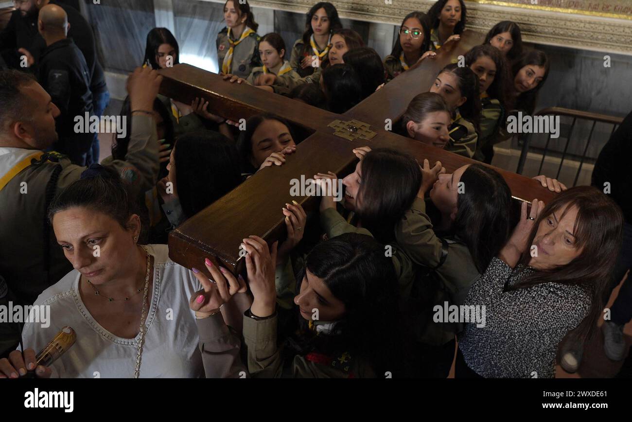 Arab Christians scouts carry a large wooden cross inside the Church of ...
