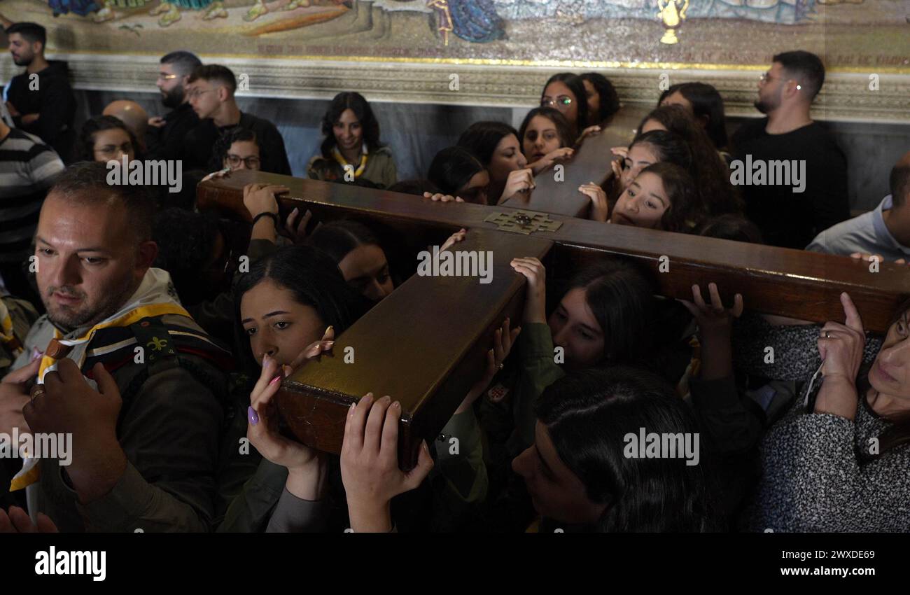 Christian Arab scouts carry a large wooden cross inside the Church of ...