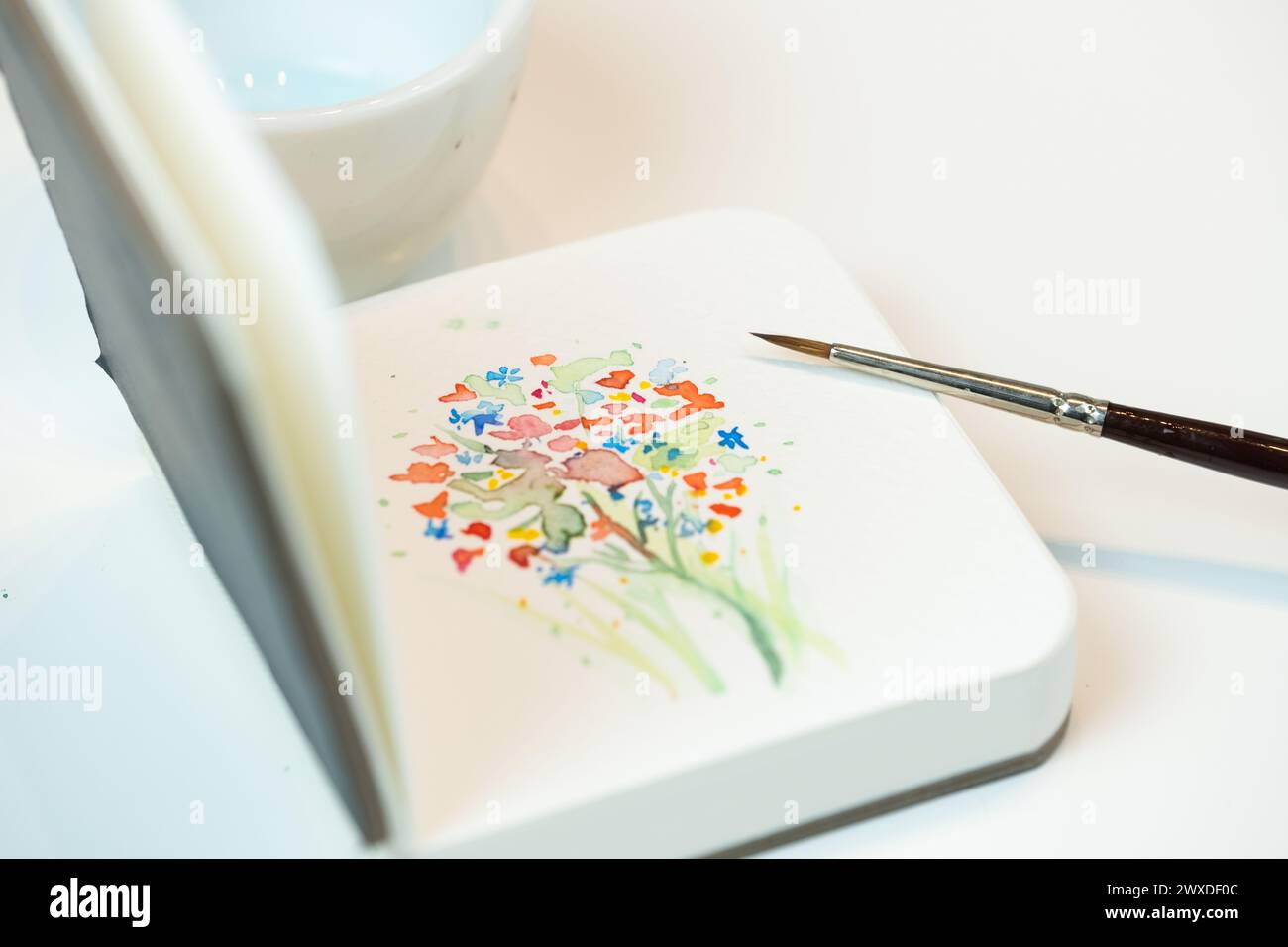 Macro detail of a mini watercolor notebook with a miniature floral ...