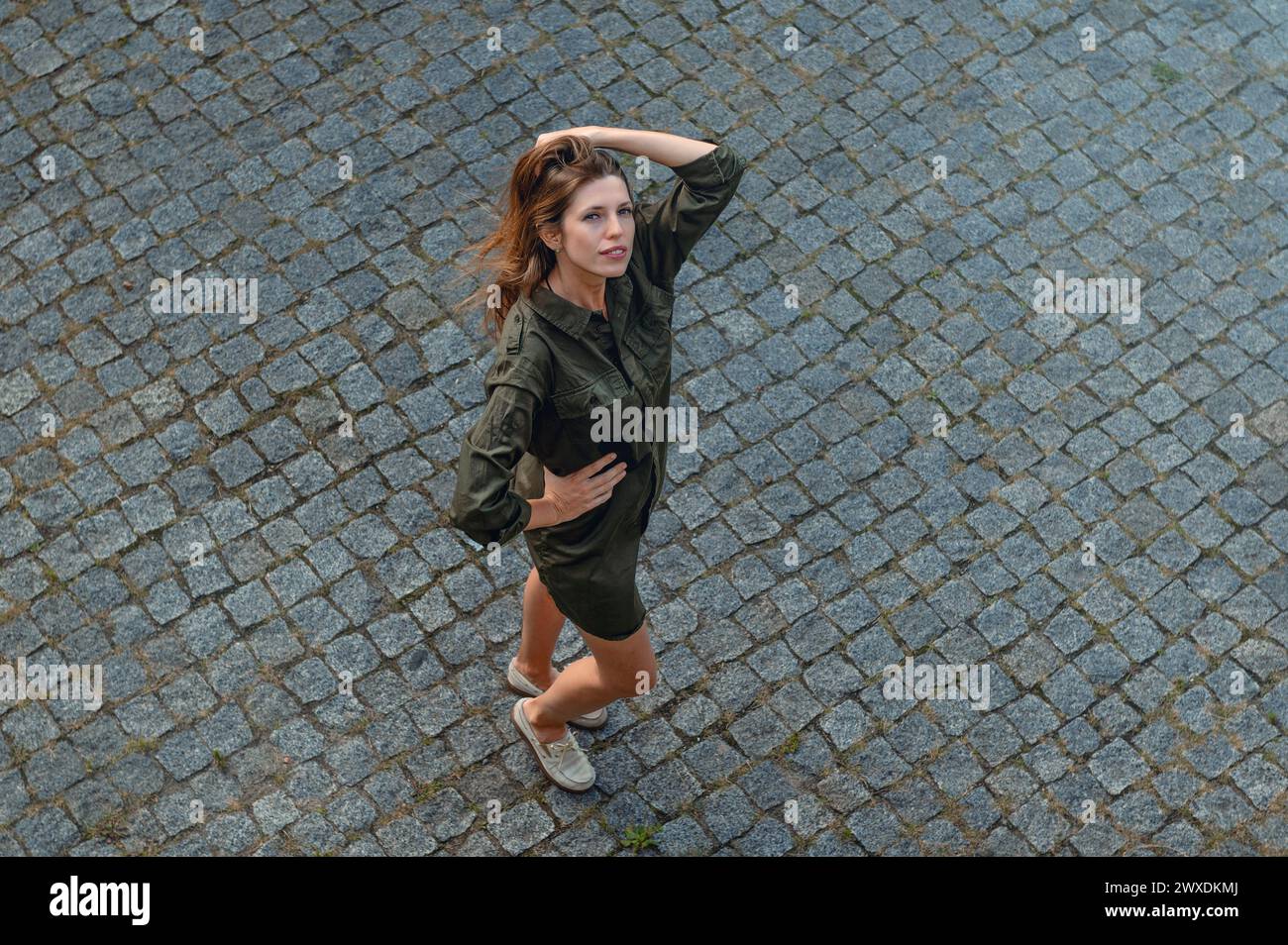 View from above of young woman looks up. Beautiful woman posing while ...