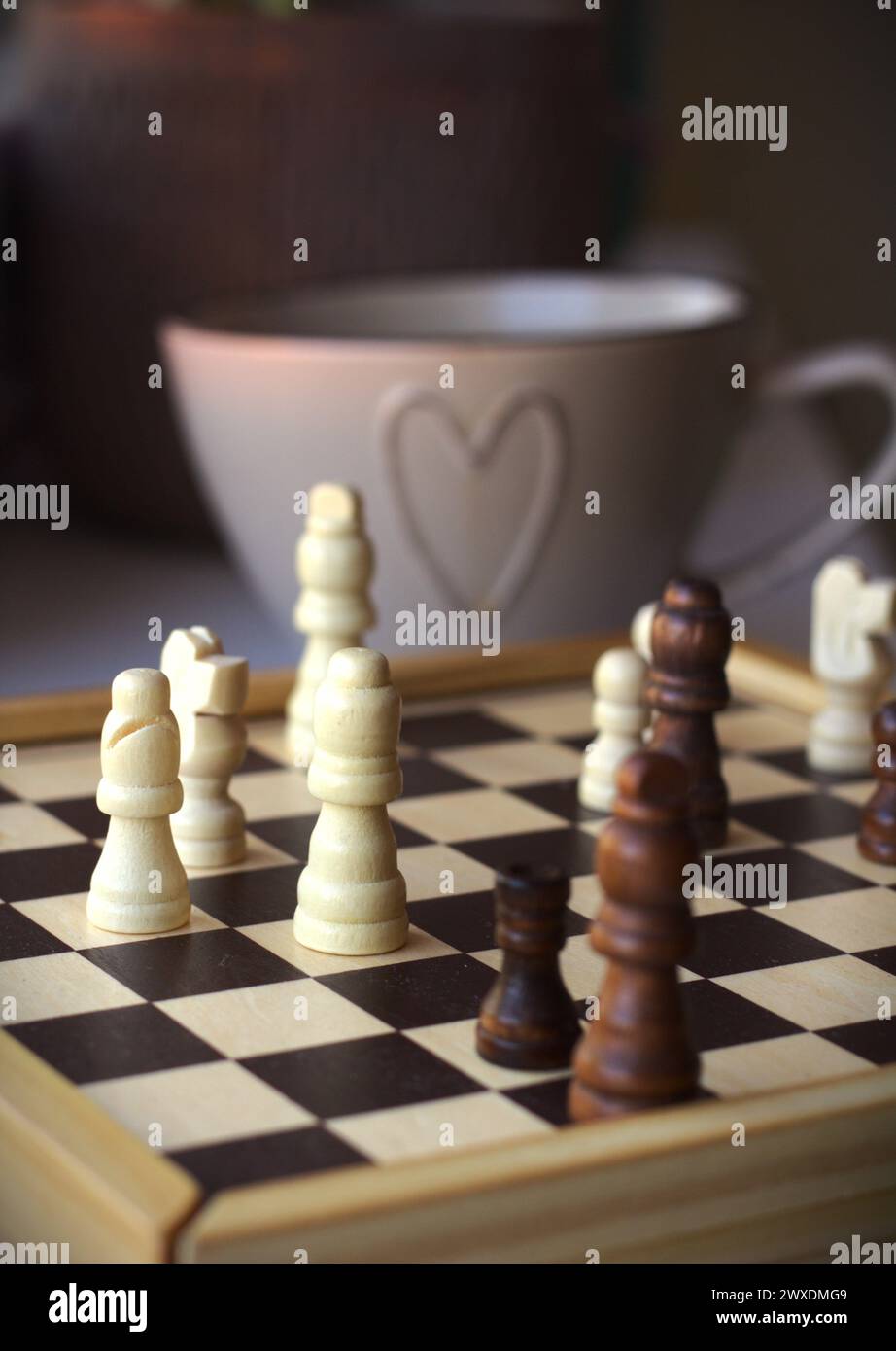 Chess game - chess board with the chess pieces and a coffee mug ...