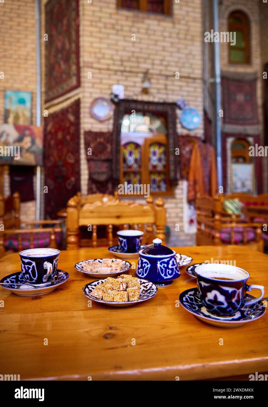 Traditional Uzbek tea table with mugs and oriental sweets in coffee ...