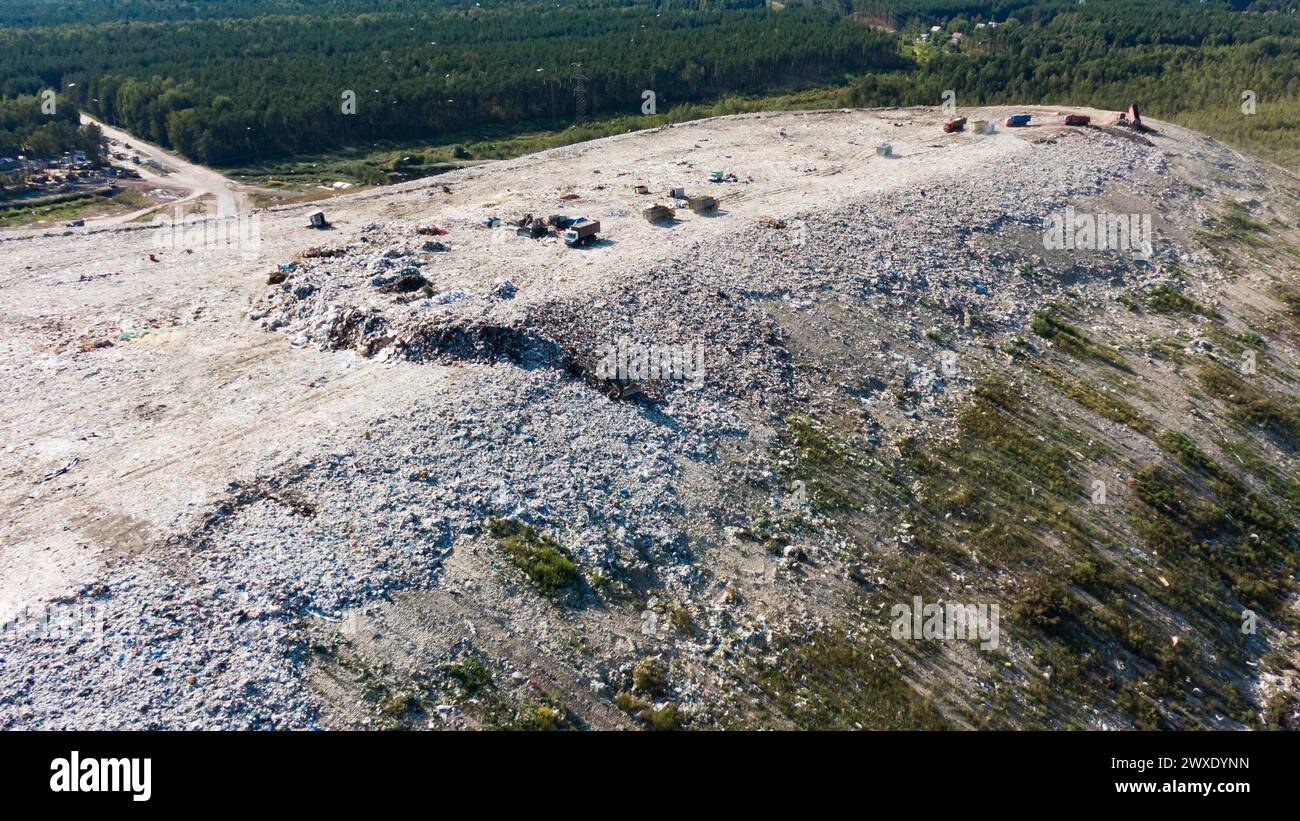 Dump trucks unload household garbage in a giant landfill in the ...