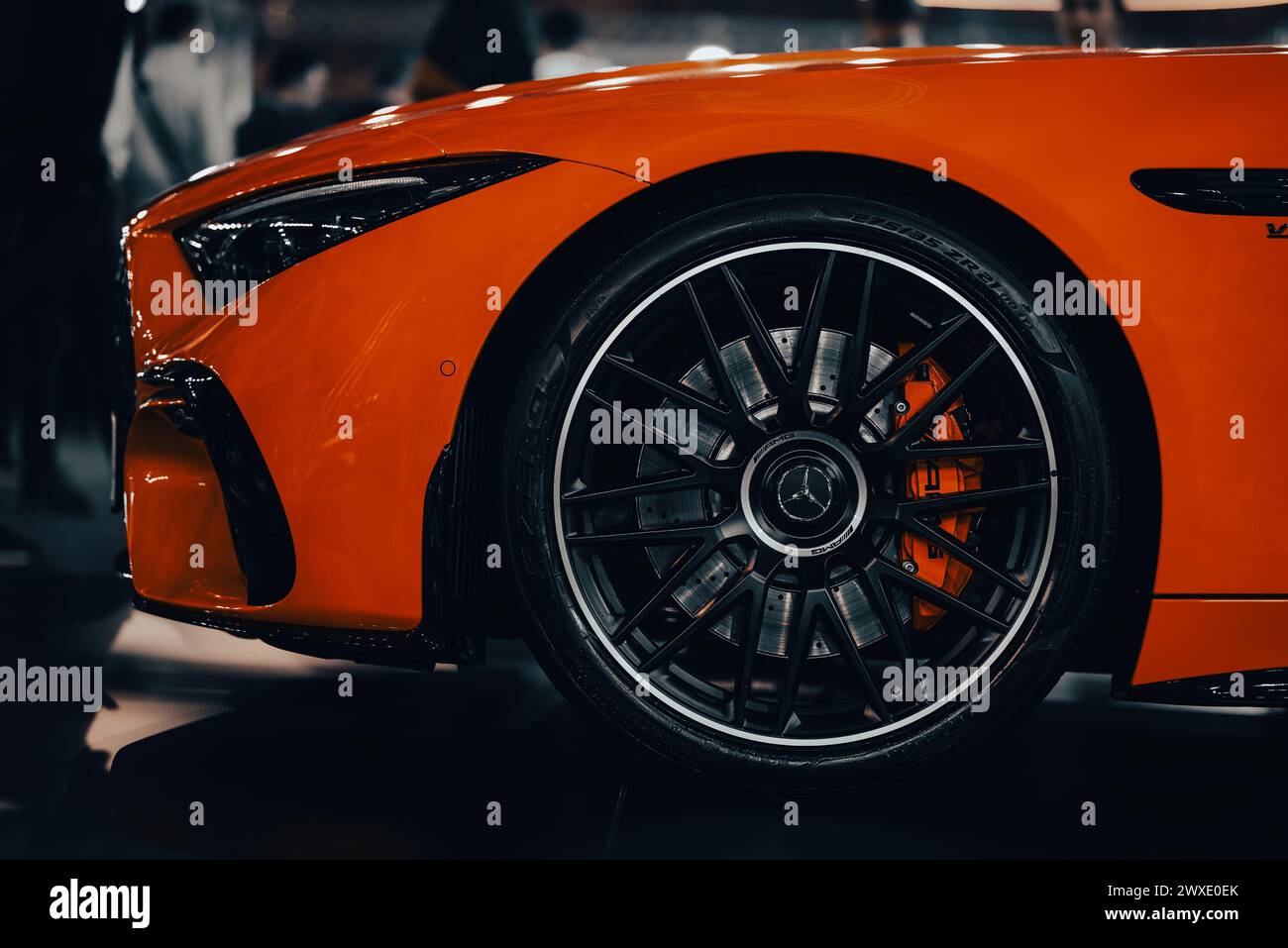 A side view of the front wheel of an orange luxury Mercedes Benz AMG SL ...