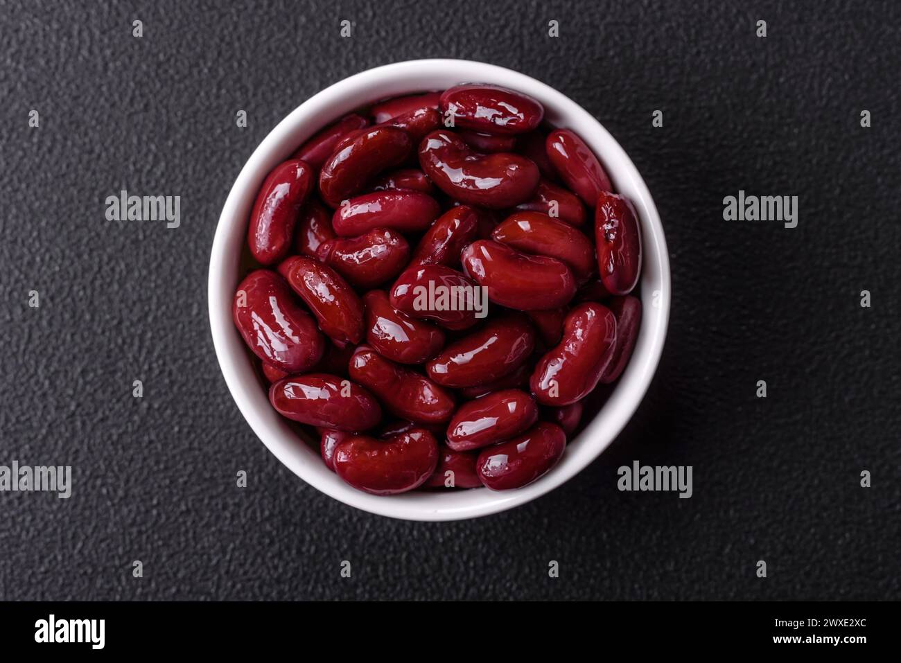 Canned red beans with salt and spices in a white bowl as an ingredient ...