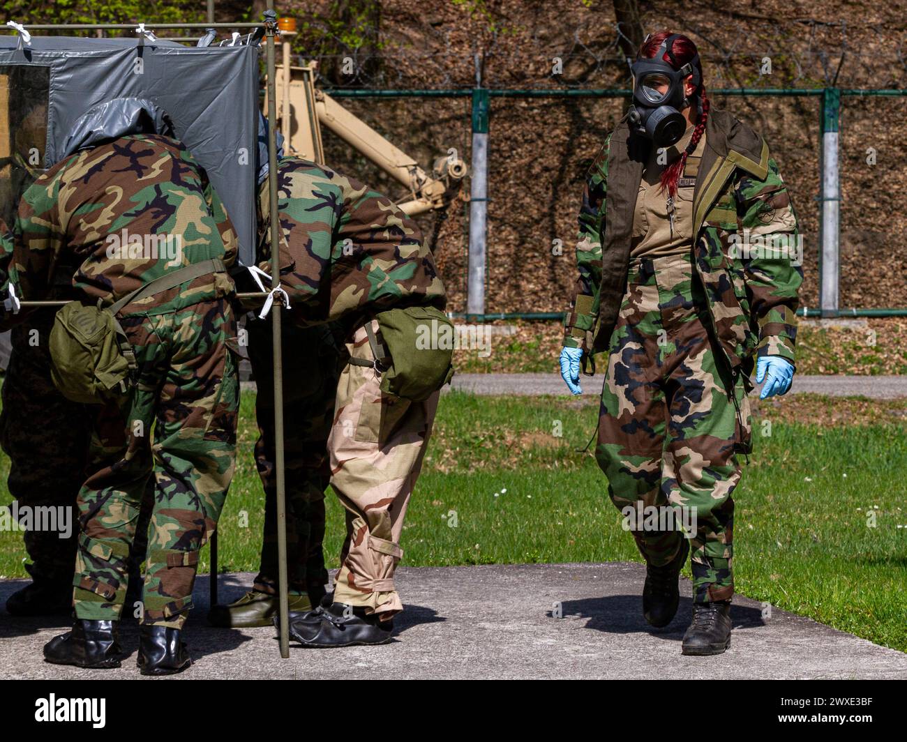 A group of soldiers in camouflage uniforms are working together. One of ...