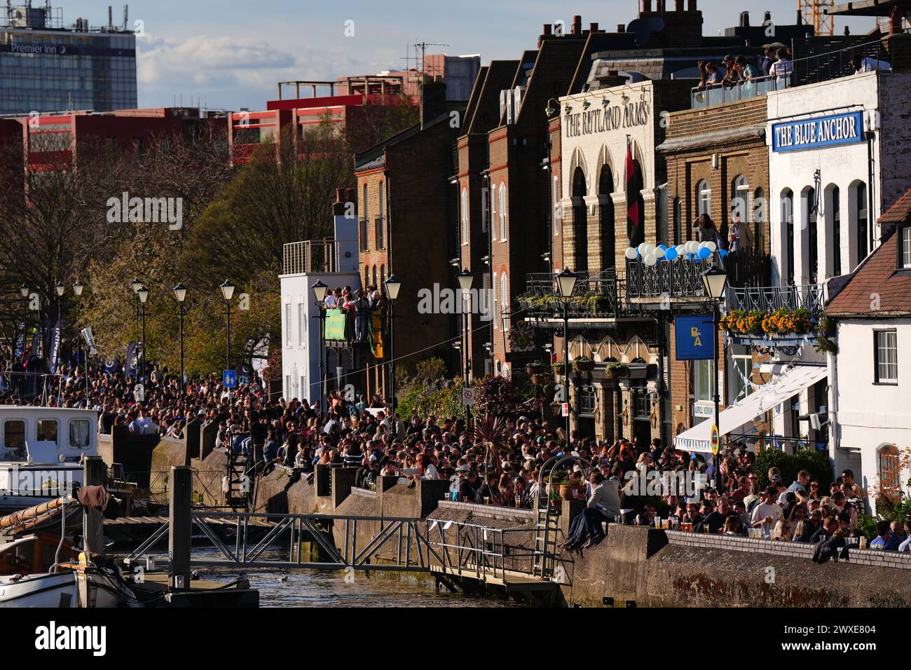 Spectators watch the 169th Men's Gemini Boat Race 2024 on the River ...