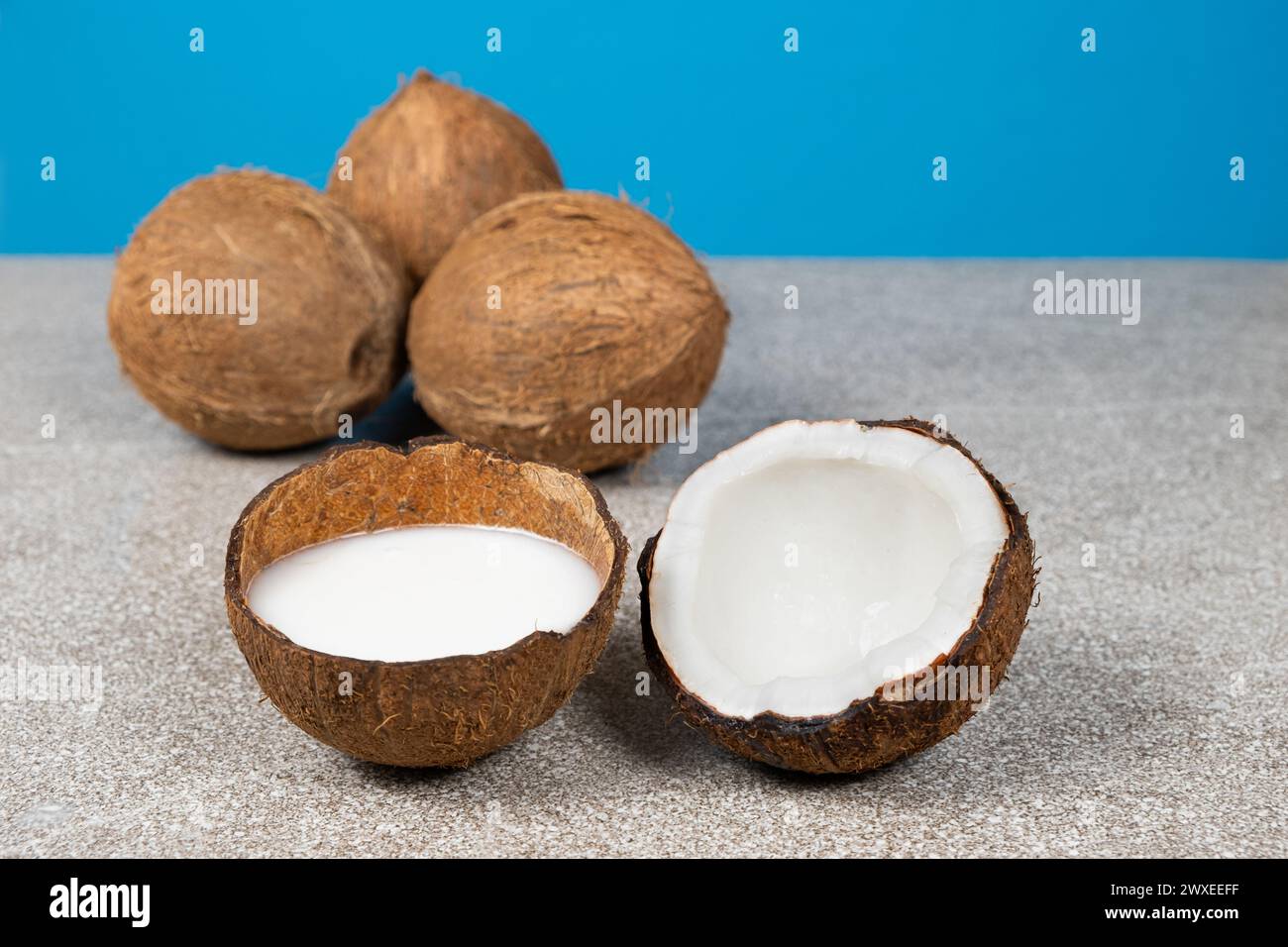 Coconut milk in coconut shell on blue grey background Stock Photo - Alamy