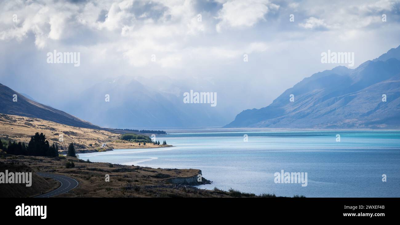 Alpine landscape scenery with azure lake, patches of sunlight and thick ...