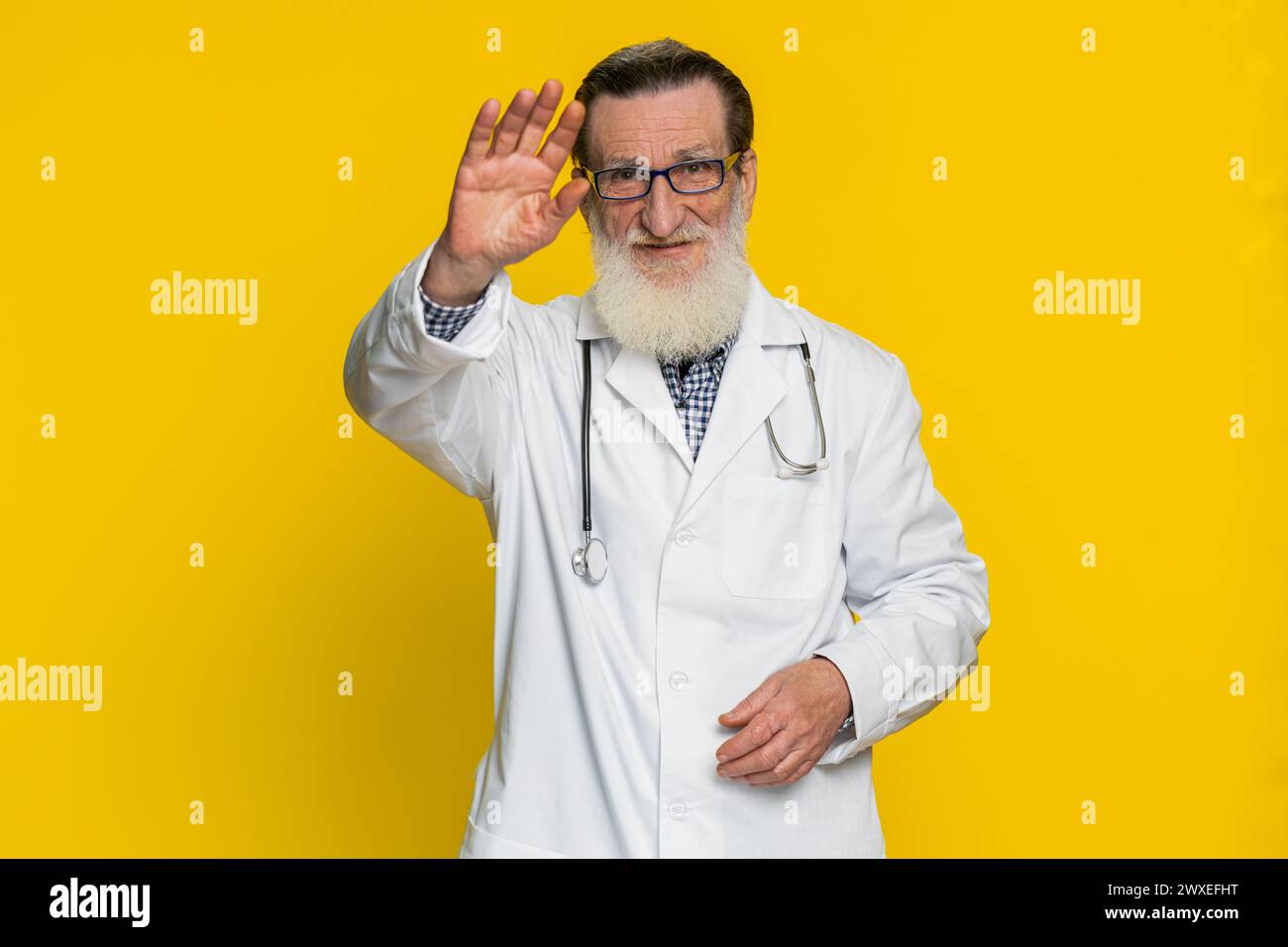 Senior smiling doctor cardiologist man waving hands gesturing hello ...