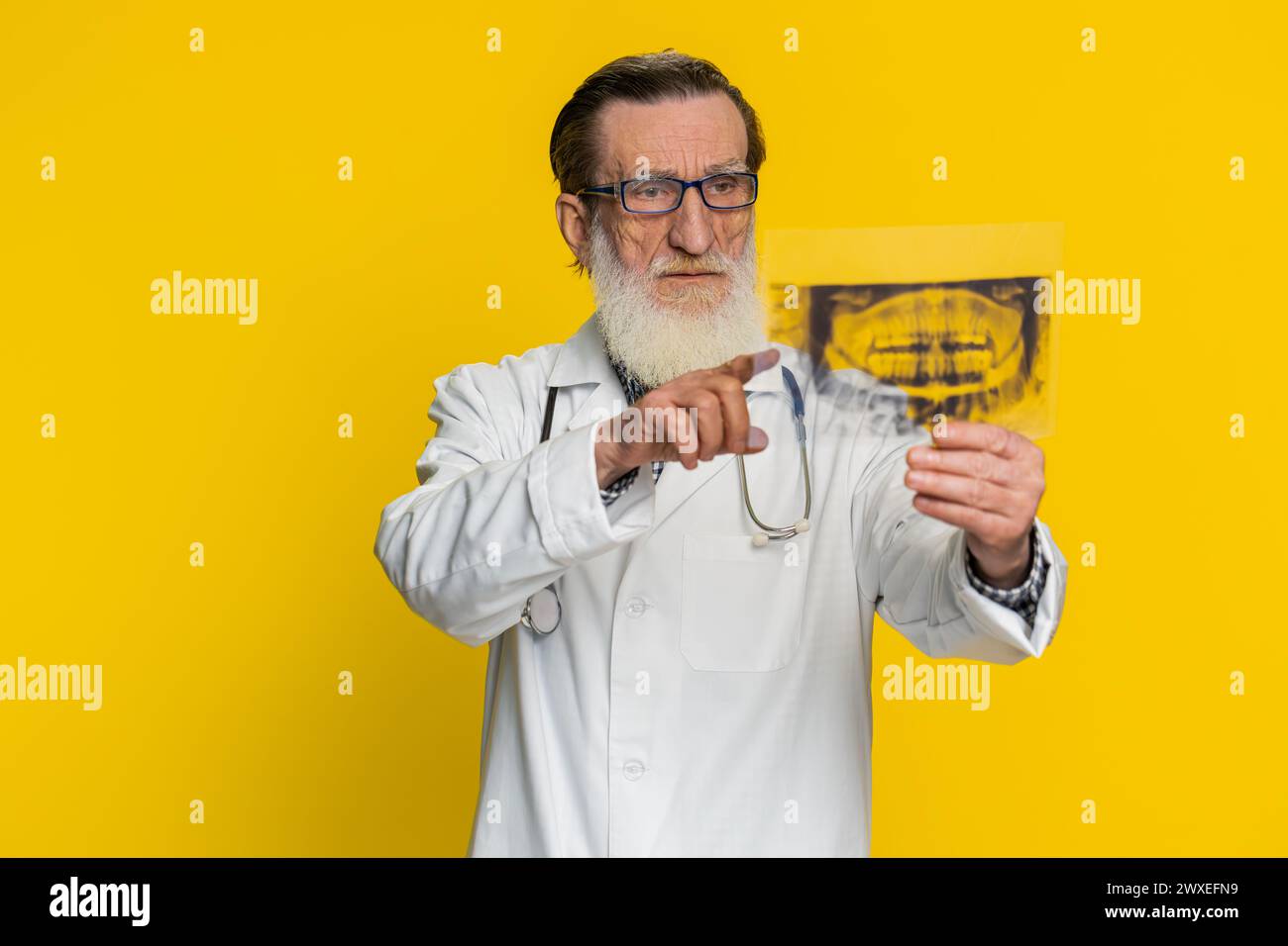 Senior elderly doctor orthodontist man examines a panoramic x-ray ...