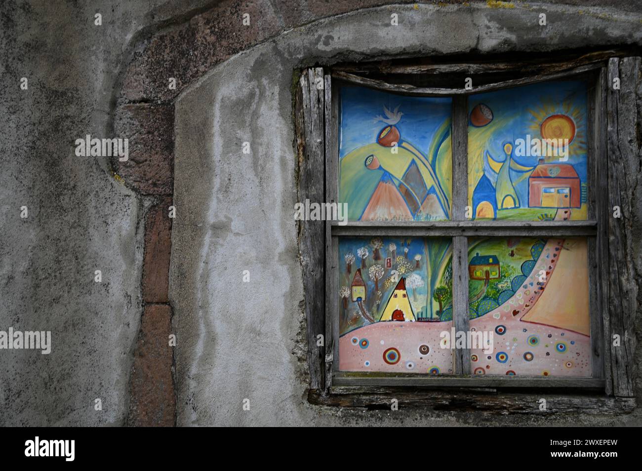 Antique window with hand painted rural scenes against a weathered ...