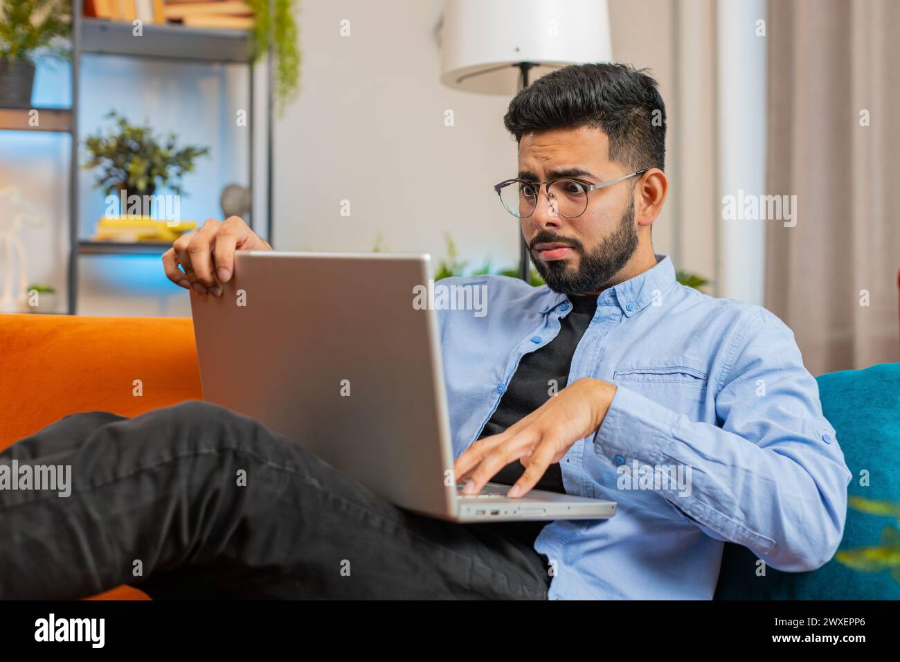 Shocked young hispanic man home hi-res stock photography and images - Alamy