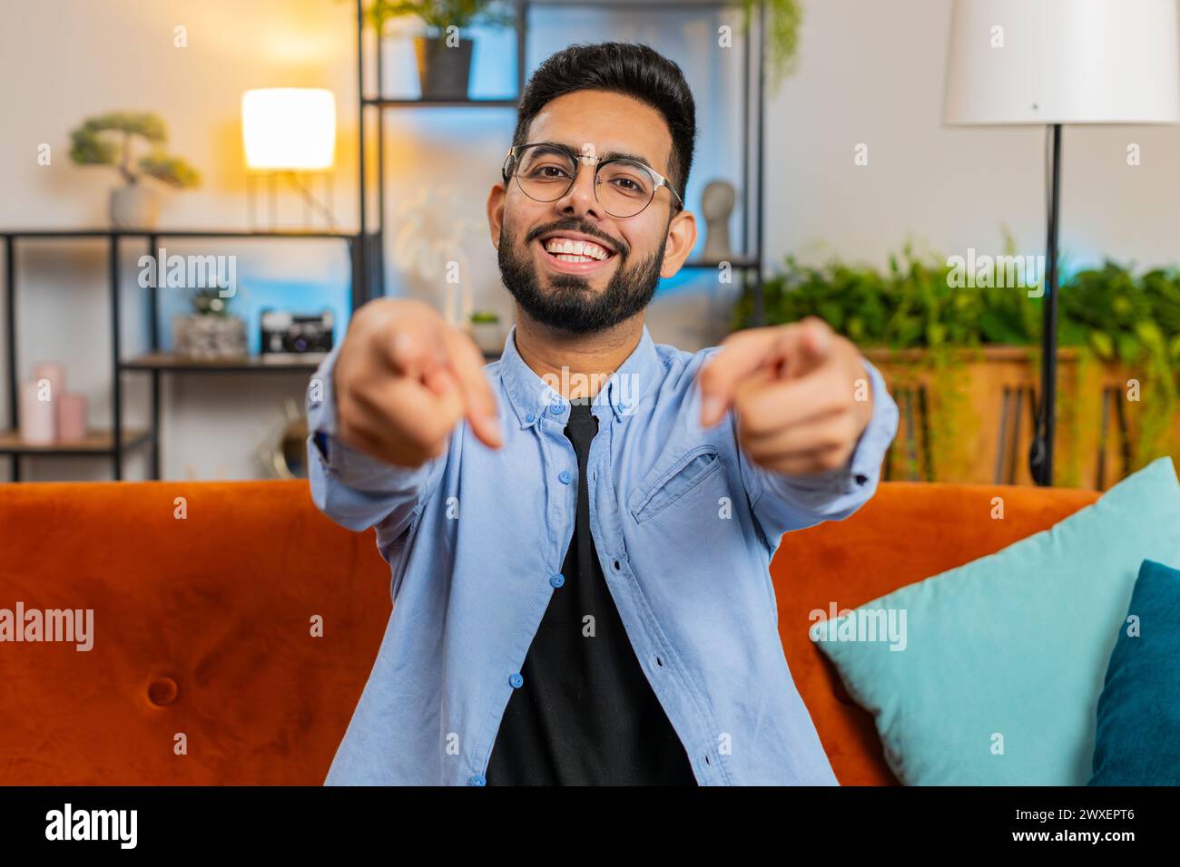 Hey you. Happy satisfied Indian man smiling and pointing to camera ...
