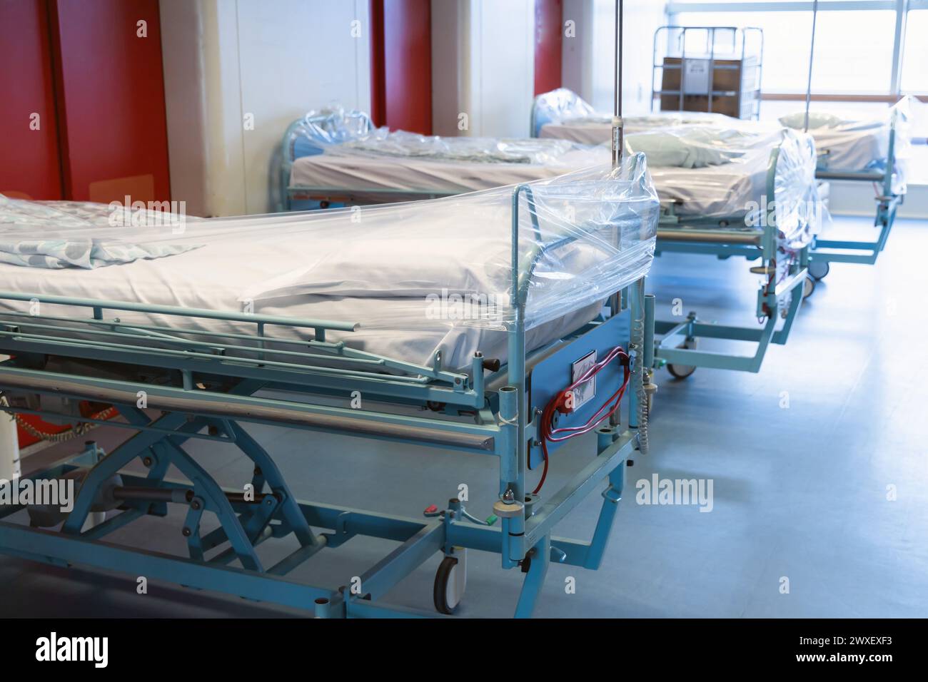 Clean hospital beds covered with film, ready for new patients. Hospital ...