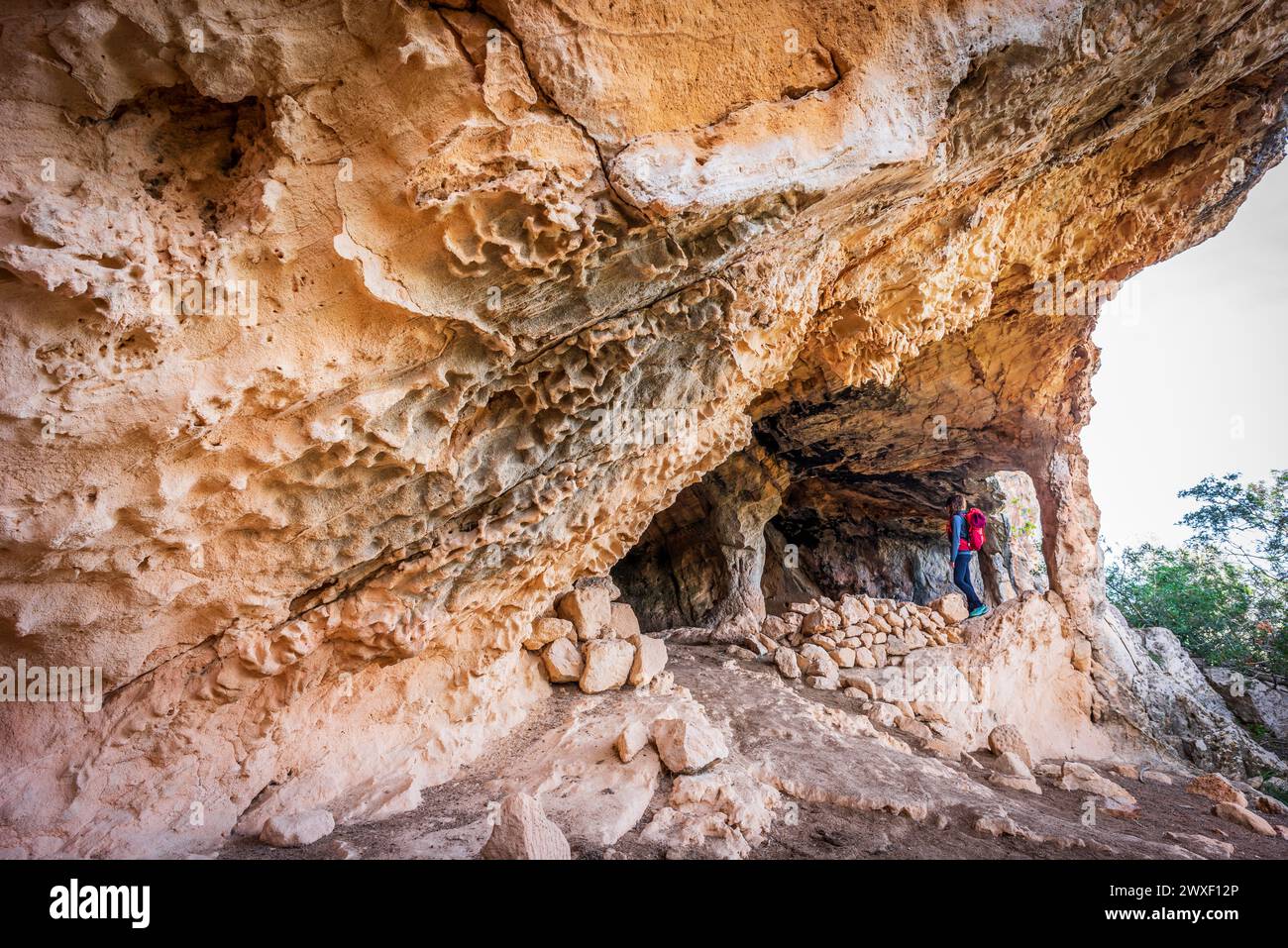 tourist in Sa Cova des Voltor, (the vulture cave), historic sandstone ...