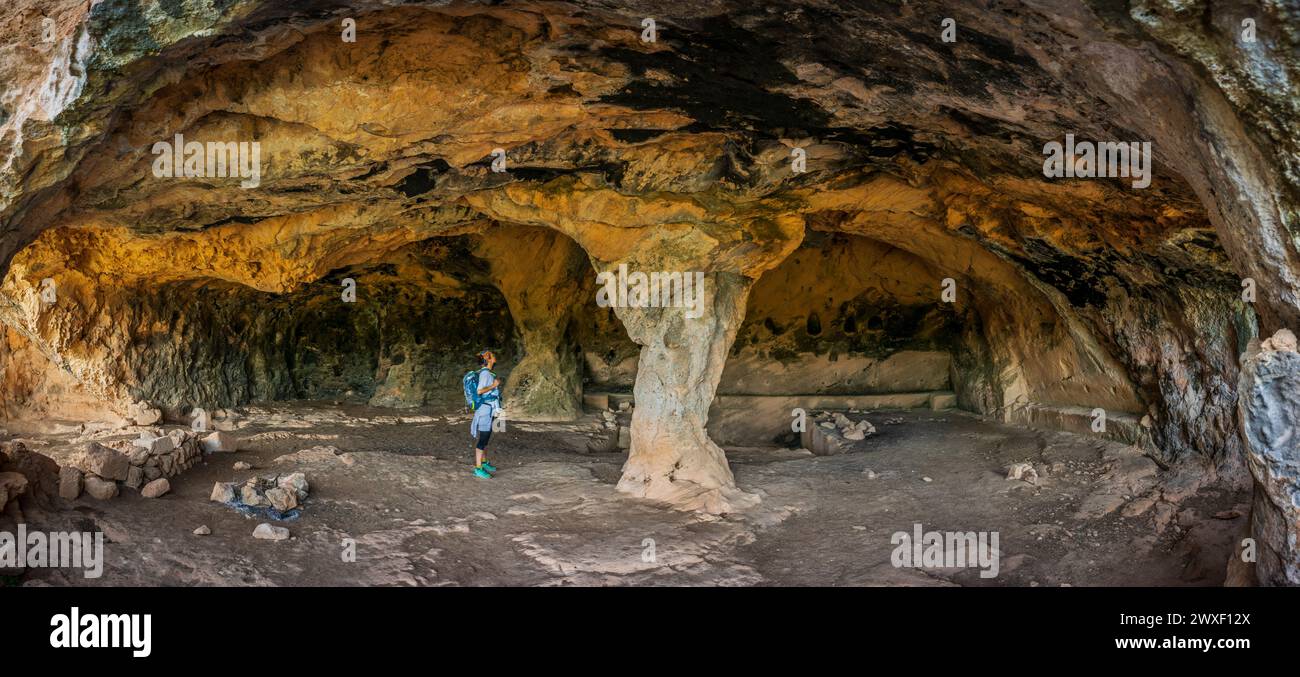 tourist in Sa Cova des Voltor, (the vulture cave), historic sandstone ...