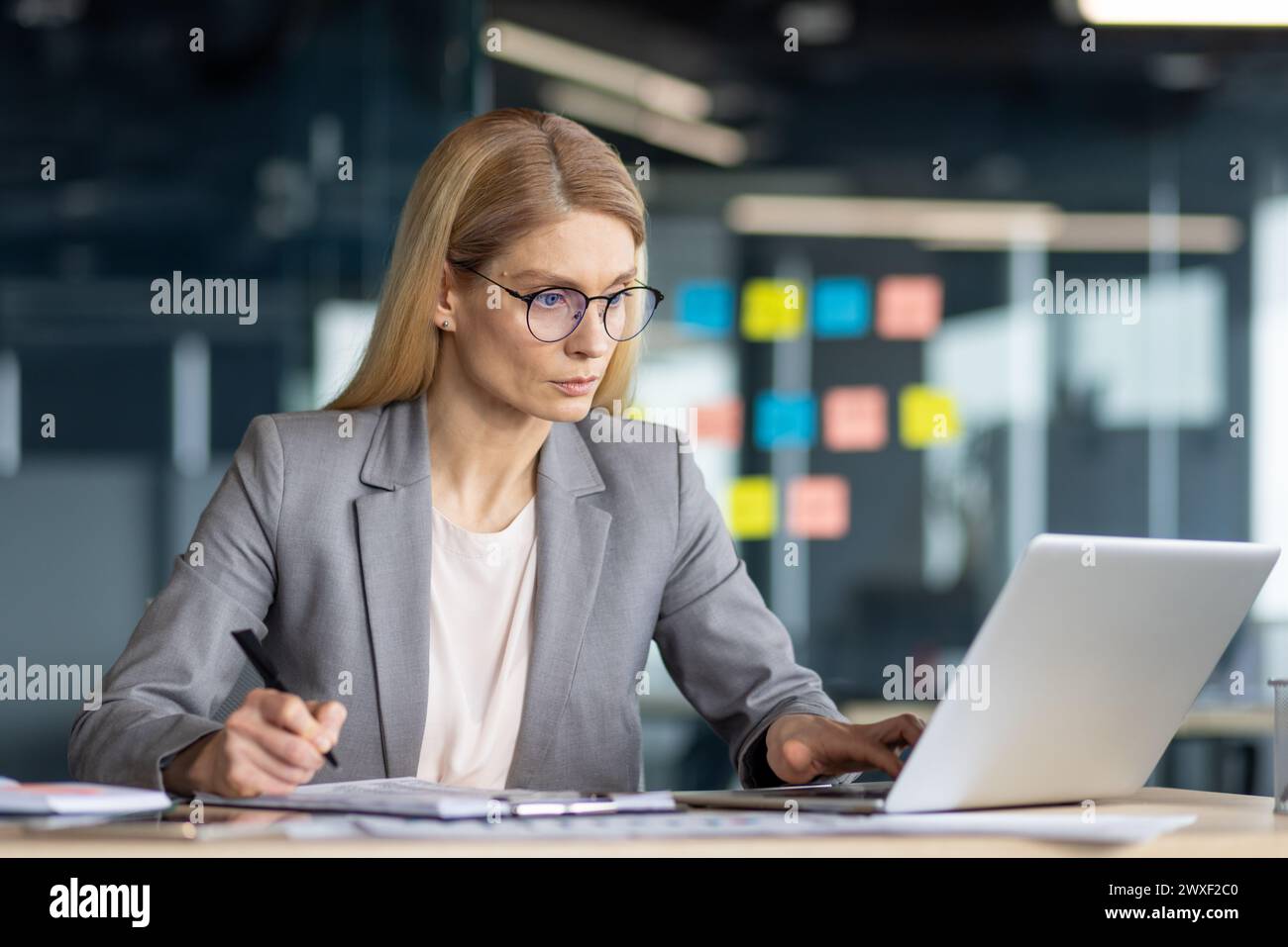 A professional businesswoman engages in serious work, meticulously ...