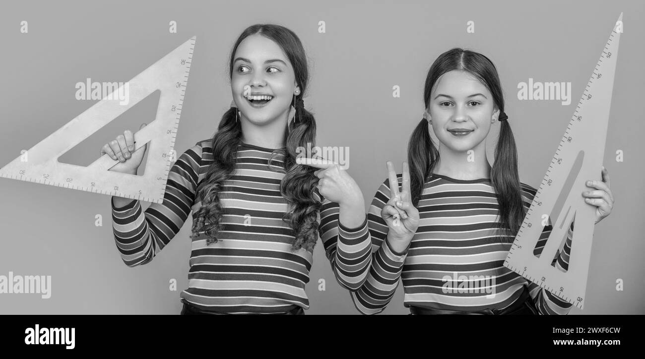 amazed school children hold math tool of triangle Stock Photo - Alamy