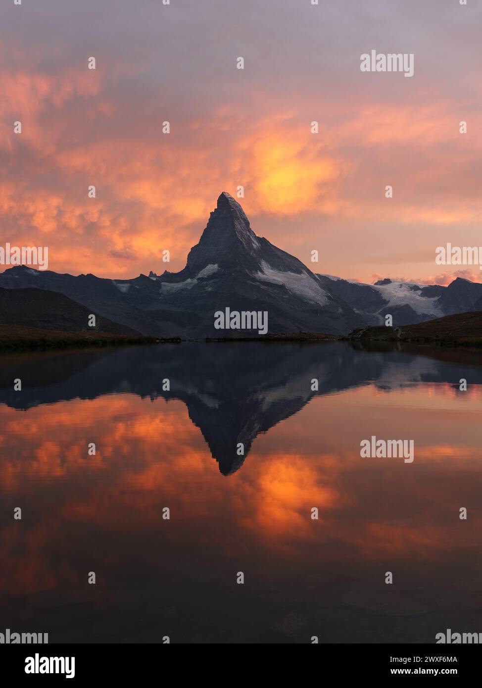 Sunset with dramatic alpenglow at the high mountain lake Stellisee with ...