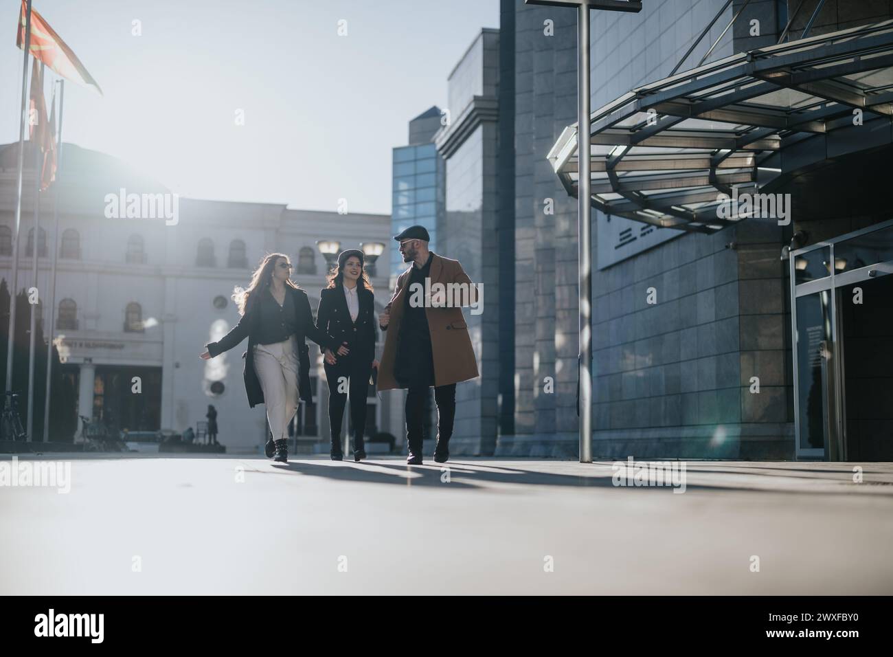 A trio of young business coworkers collaborating while walking in a ...
