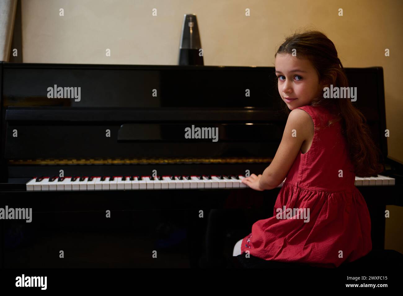 Authentic beautiful little child girl in elegant red dress, looking at ...