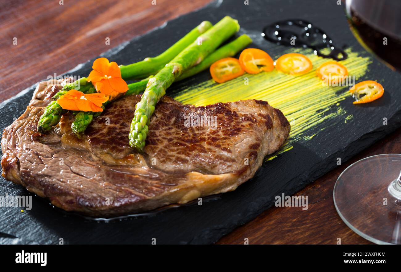 Juicy roasted beef entrecote with asparagus and slices of kumquat Stock ...