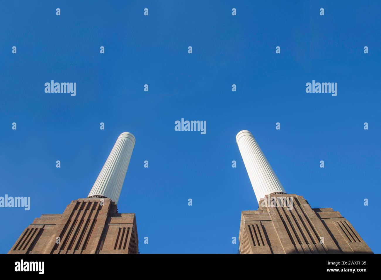 Two Isolated Battersea Power Station Chimneys London against a blue sky ...