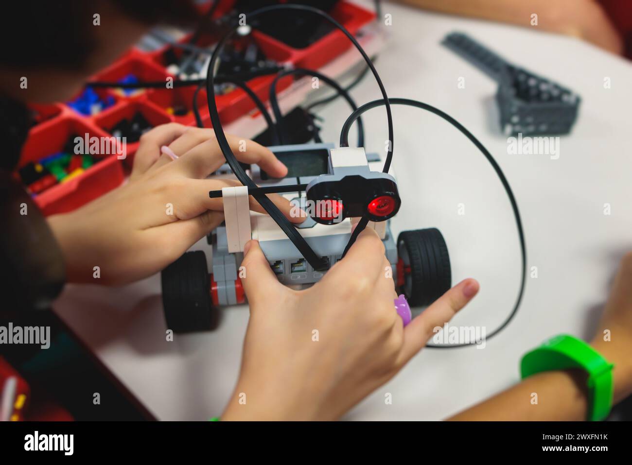 Group of diverse children kids with robotic vehicle model, close-up view on hands, science and ...