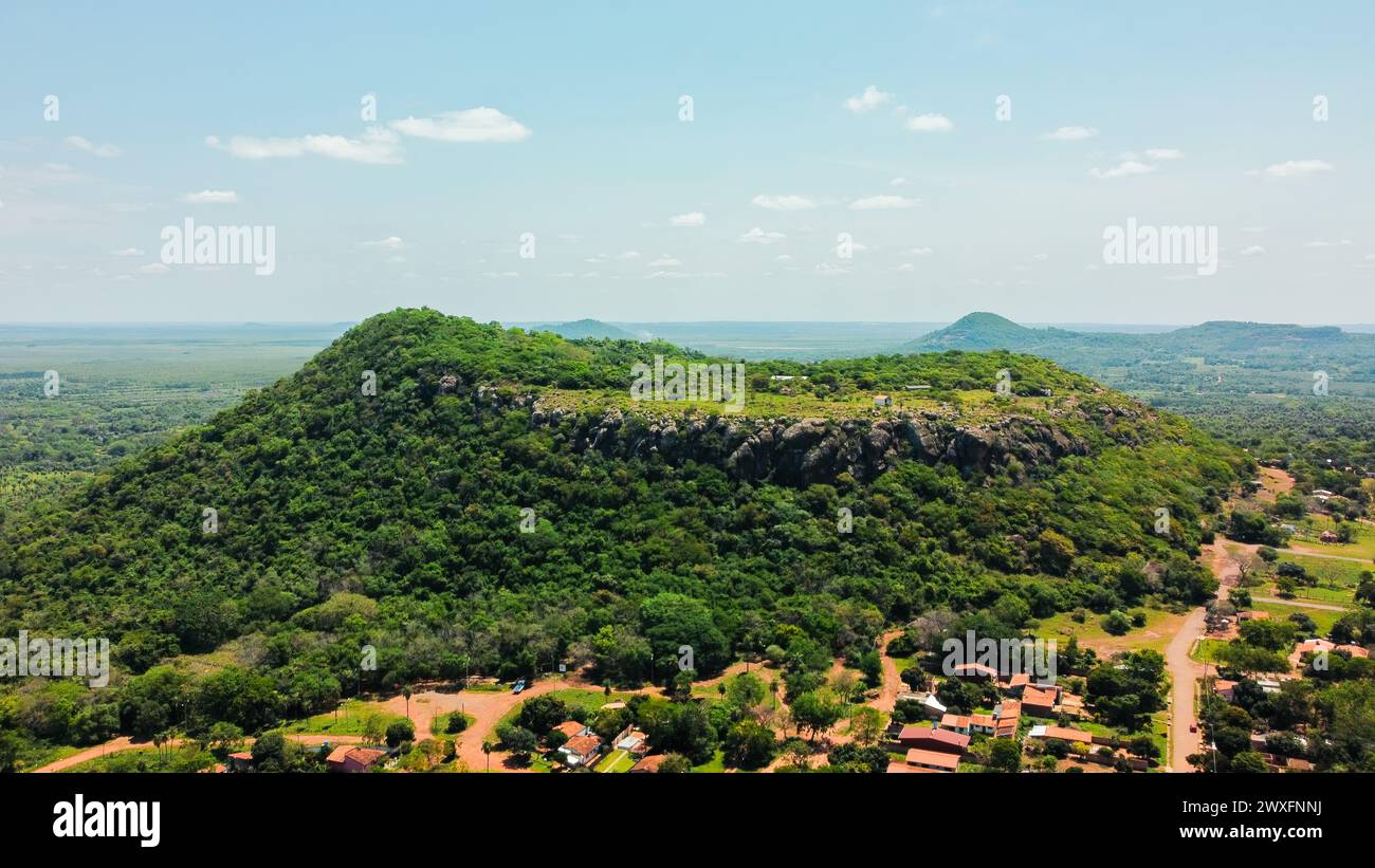 A mountain with abundant vegetation, houses scattered along its slopes ...
