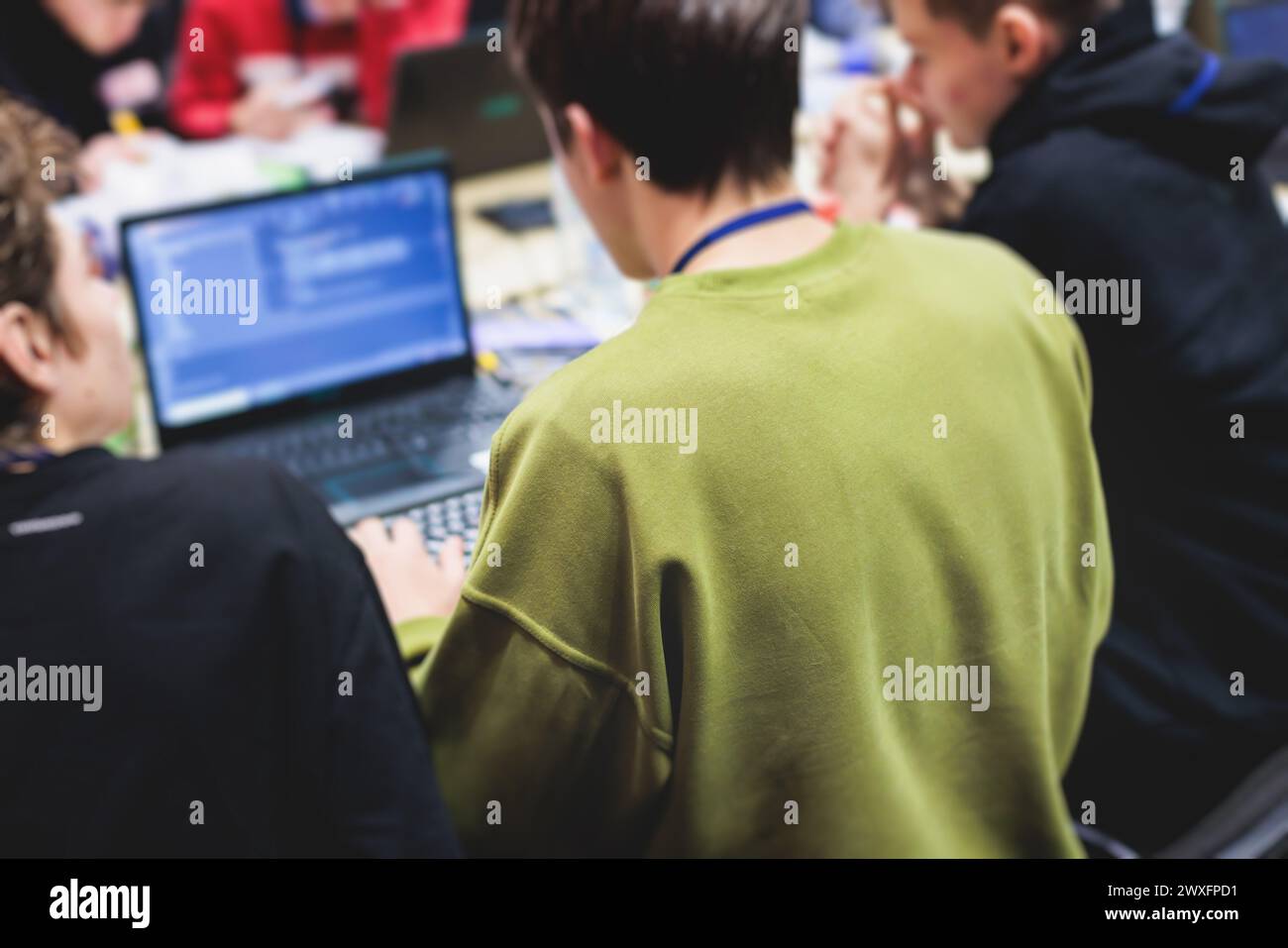 Software developer students in auditorium hall working on computer and ...