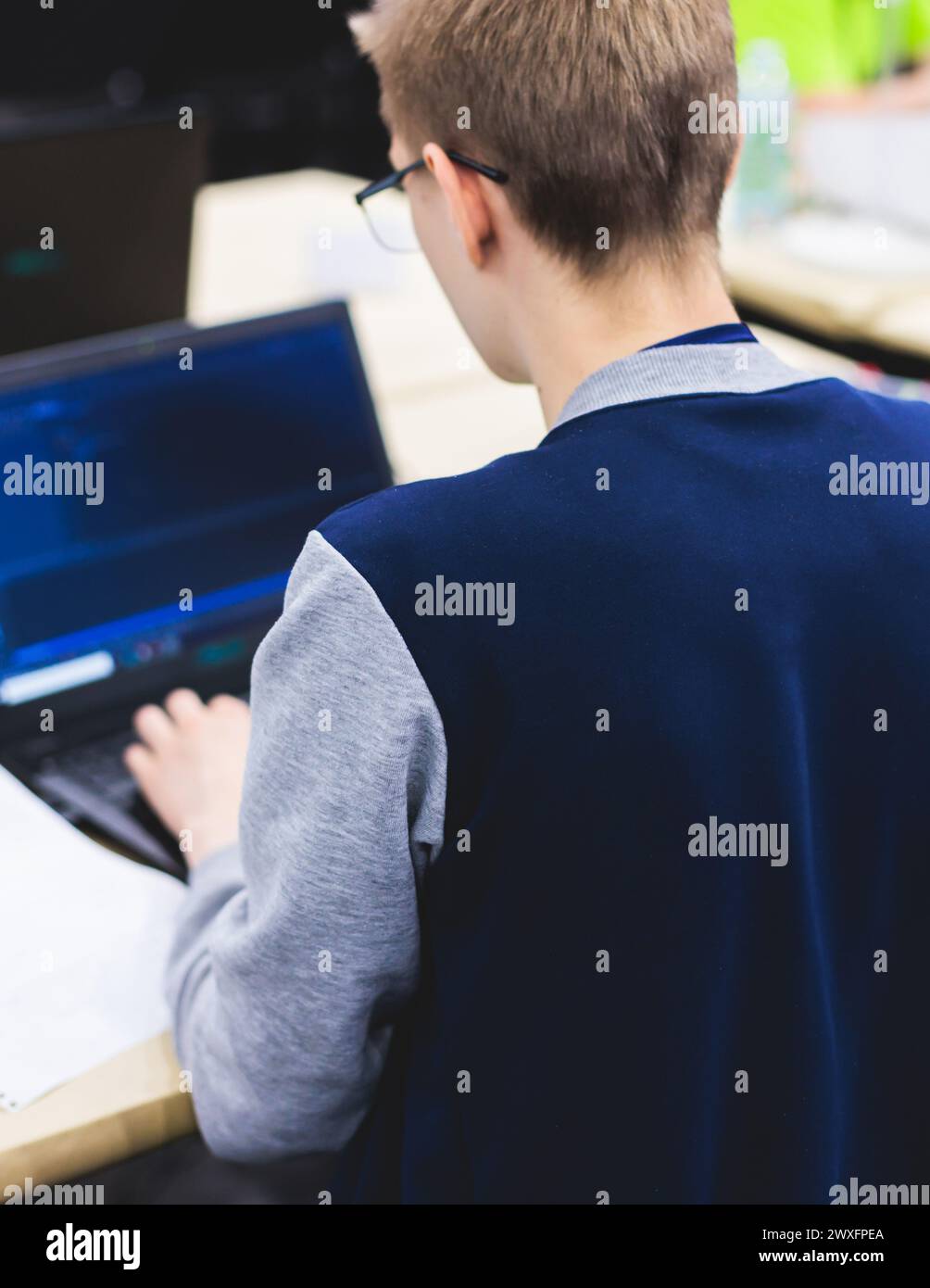 Software developer students in auditorium hall working on computer and ...