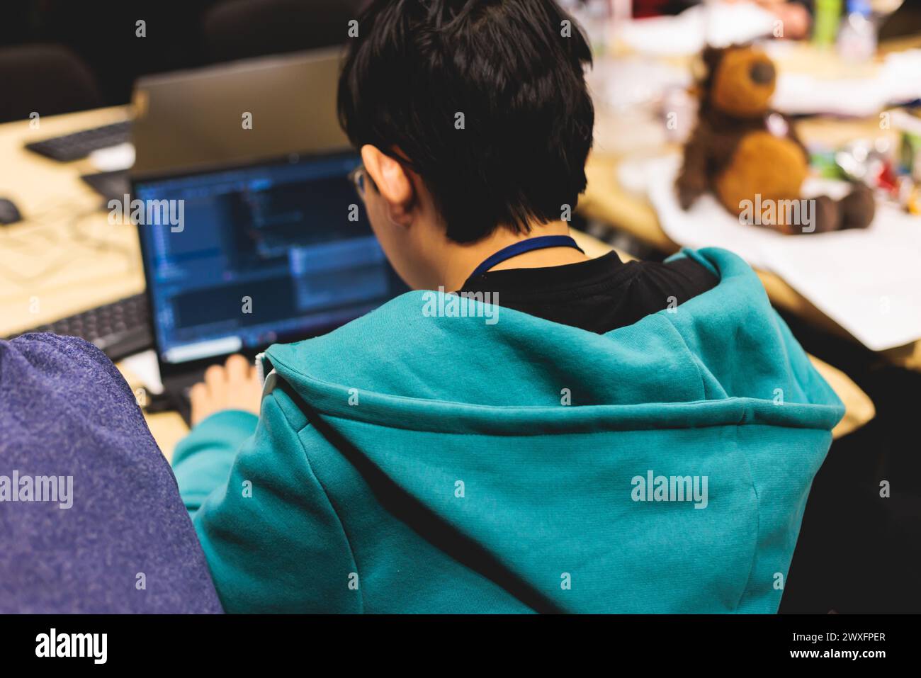 Software developer students in auditorium hall working on computer and ...