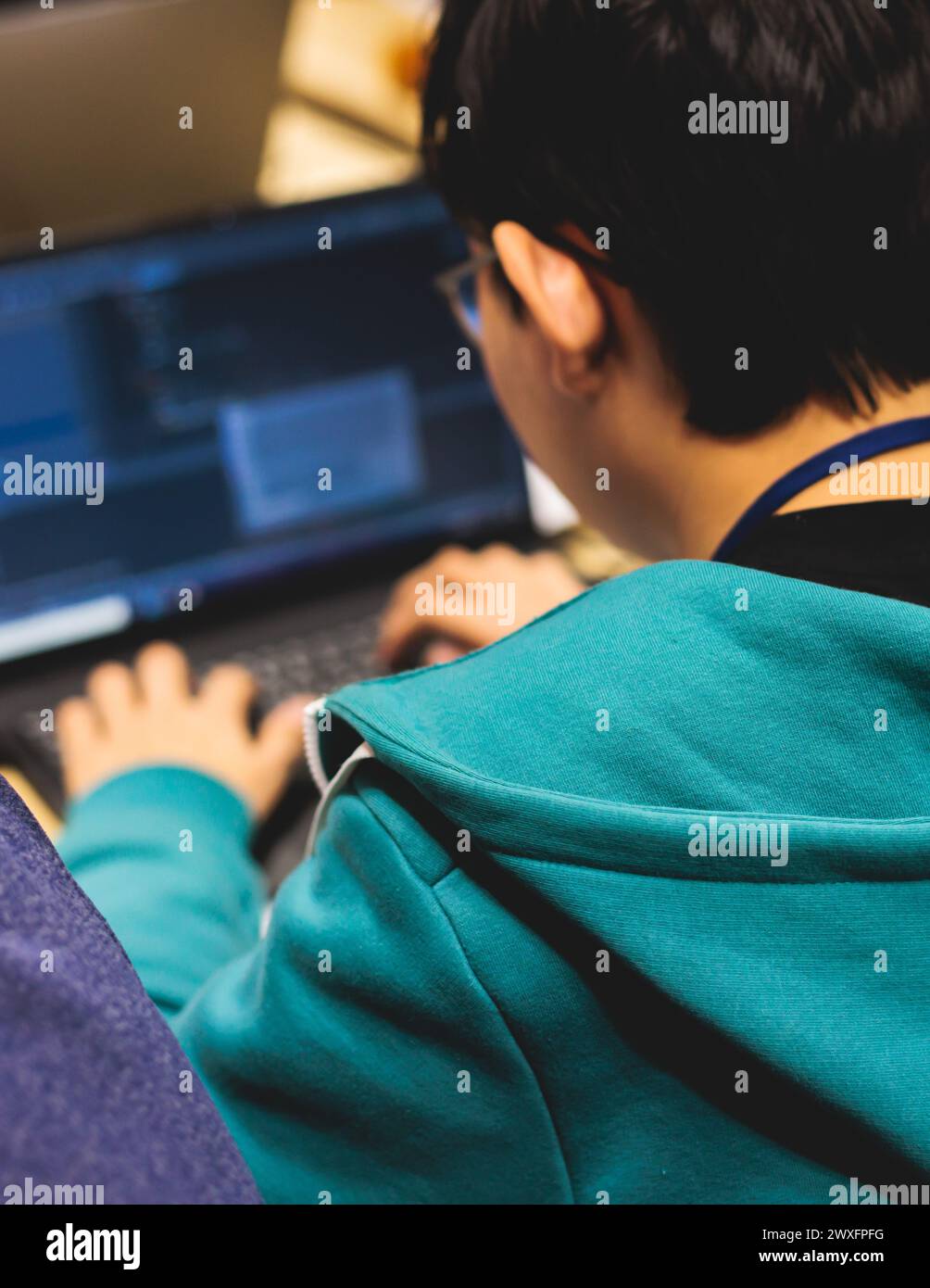 Software developer students in auditorium hall working on computer and ...