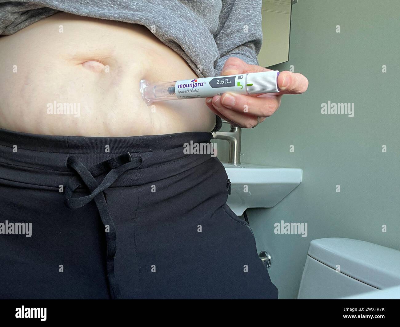 Woman injects herself in the abdomen with Mounjaro Stock Photo - Alamy