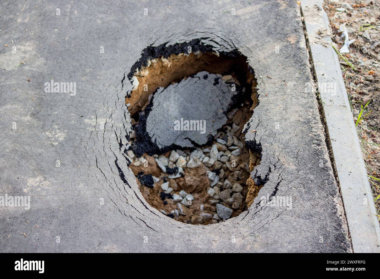 Failure of asphalt on the sidewalk. A hole in the road. Erosion of the ...