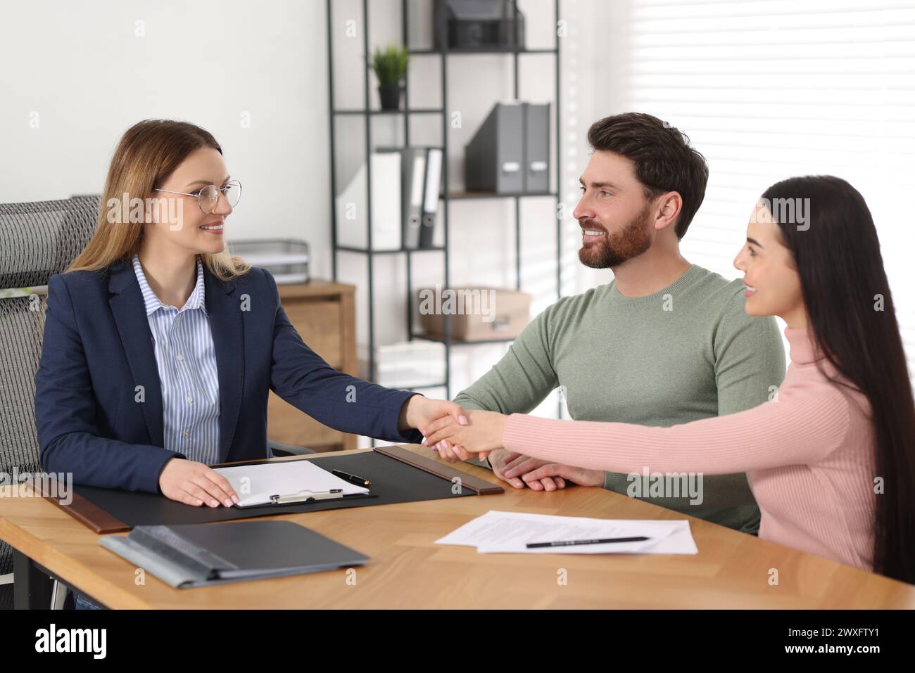 Lawyer shaking hands with clients in office Stock Photo - Alamy