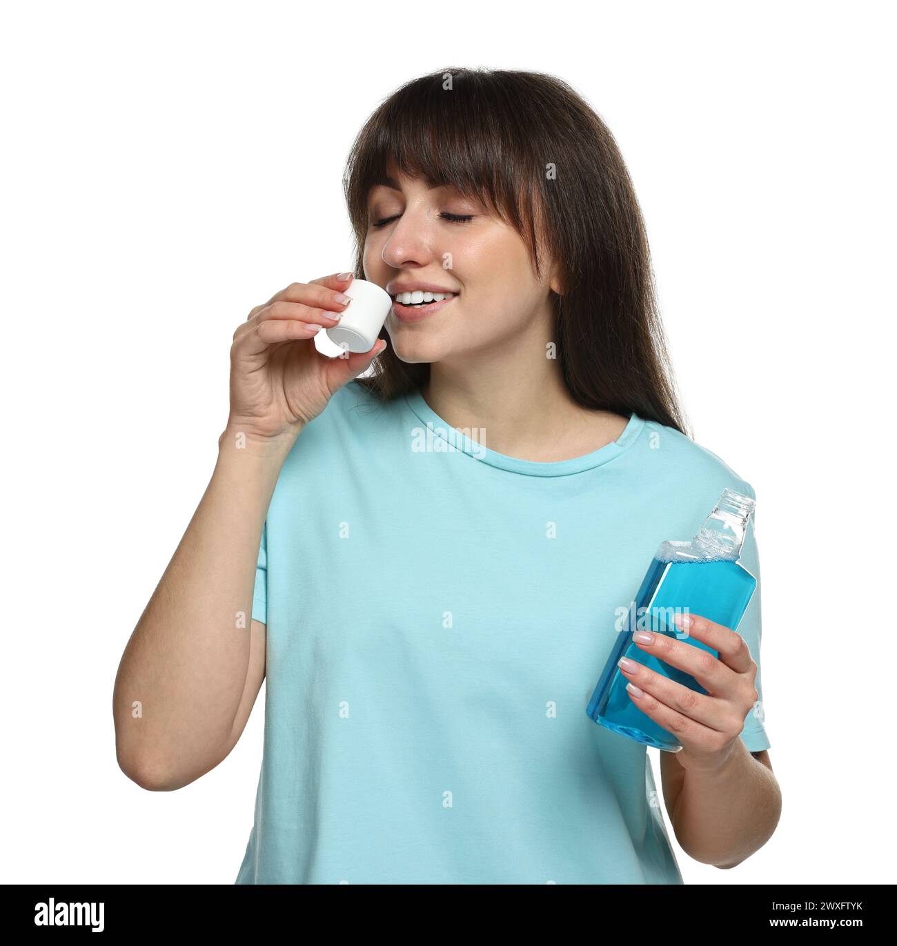 Young woman using mouthwash on white background Stock Photo - Alamy