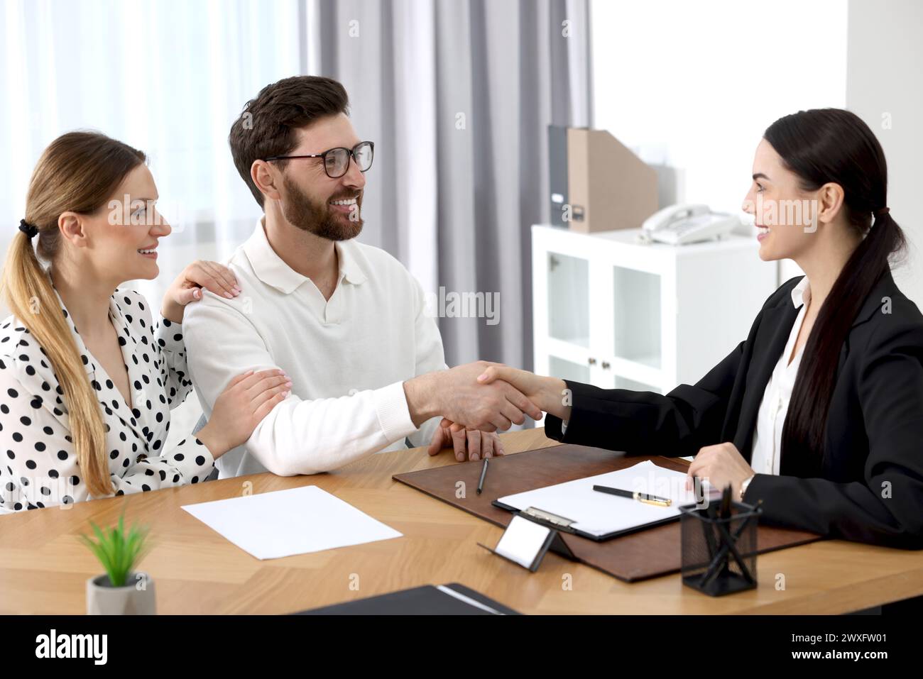 Lawyer shaking hands with clients in office Stock Photo - Alamy