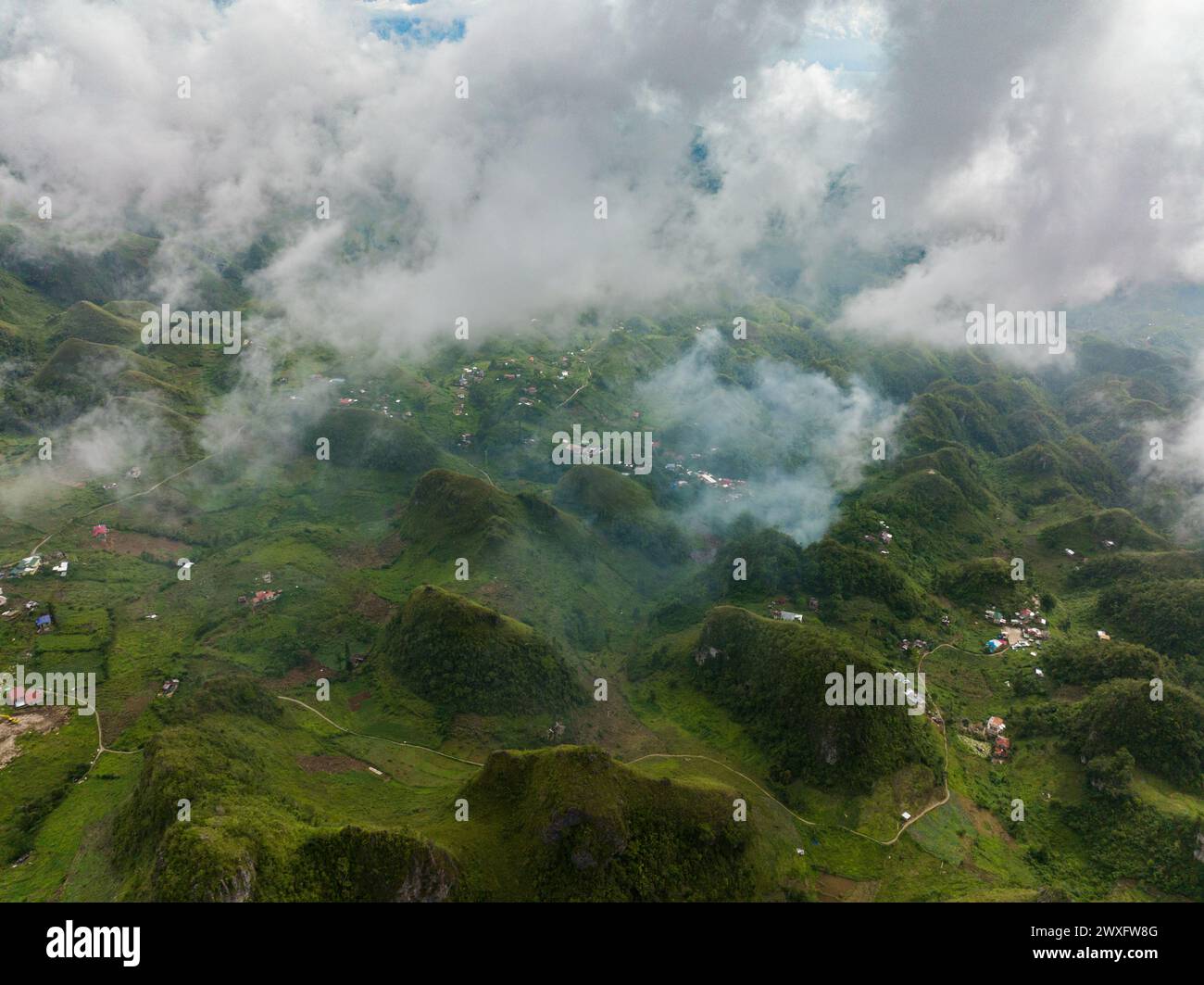 Aerial drone of mountain peaks and hills covered with green vegetation ...