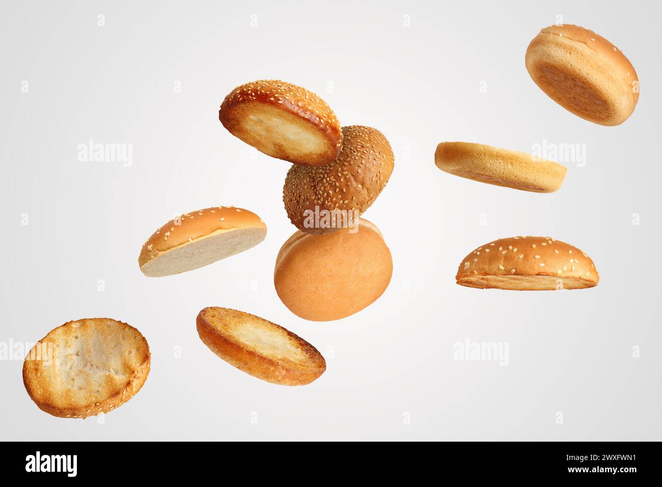 Fresh burger buns falling on light grey background Stock Photo - Alamy