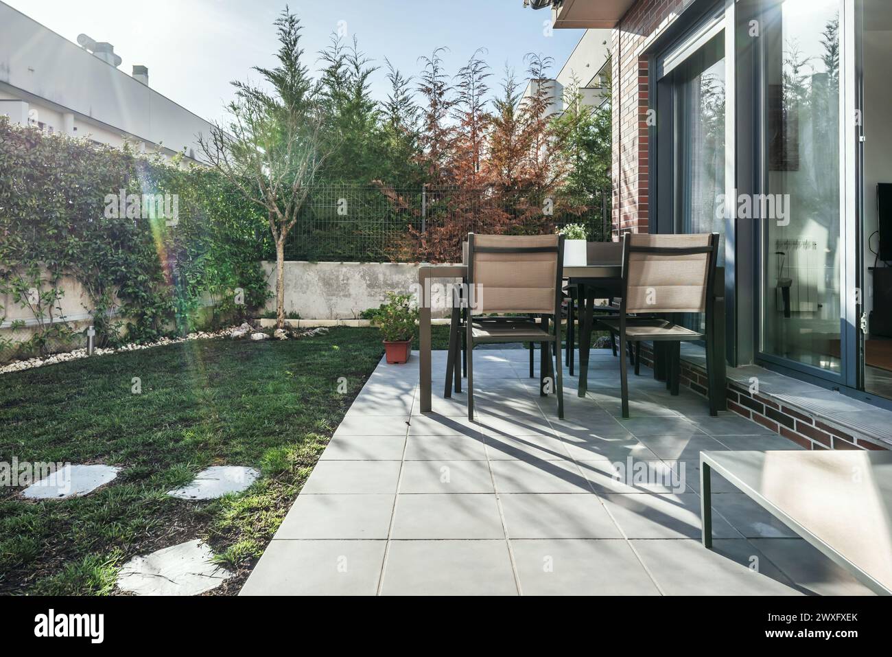 garden of a multi-storey detached house with an outdoor dining table ...