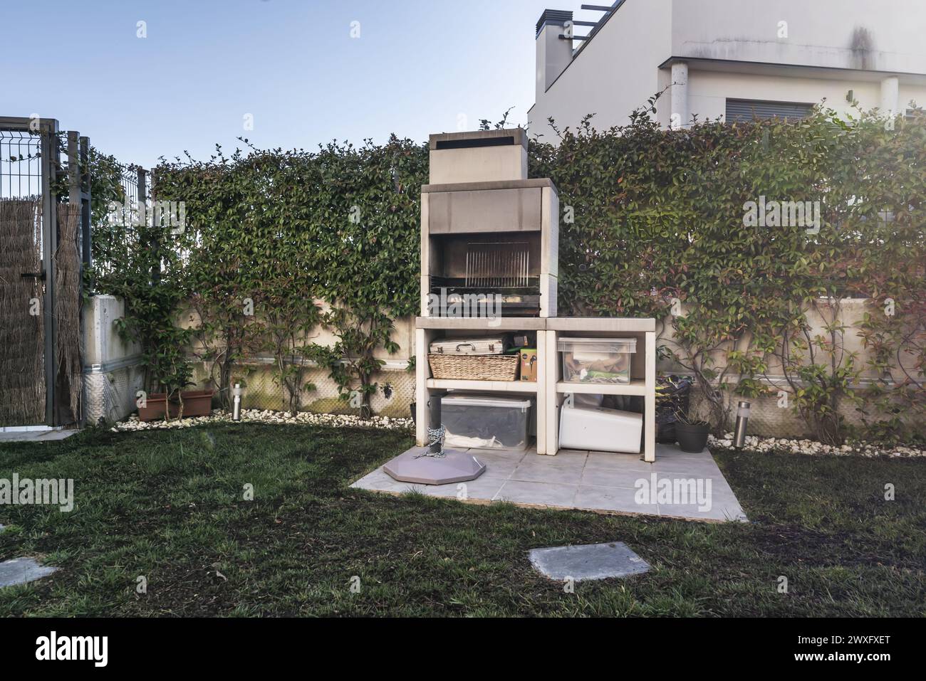 A barbecue in the garden of a single-family house with slate paths ...