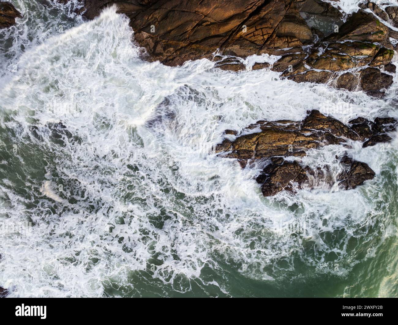 Waves crashing on seashore rocks,Top view sea surface waves background ...