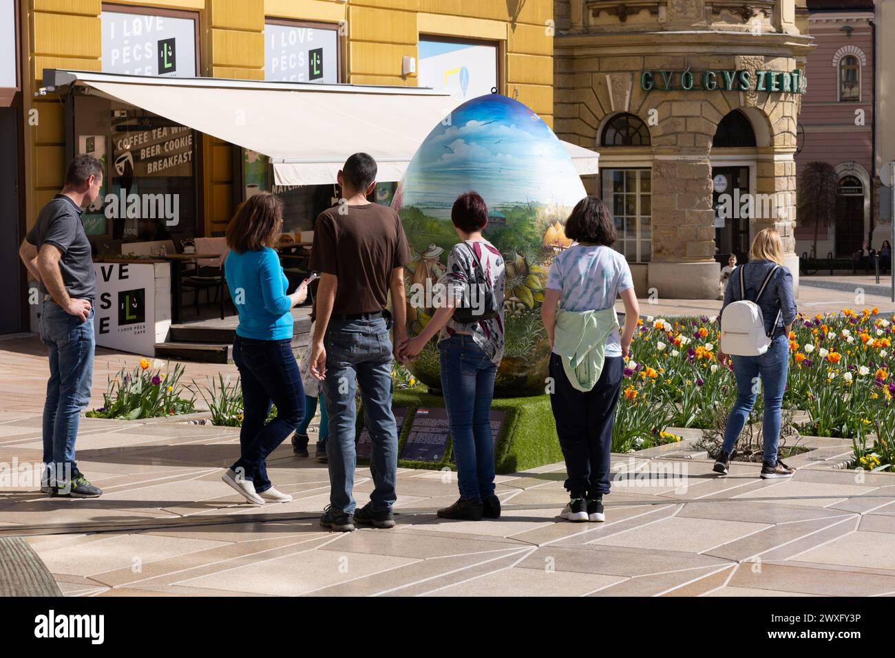 Pecs. 30th Mar, 2024. People look at a two-meter tall Easter egg ...