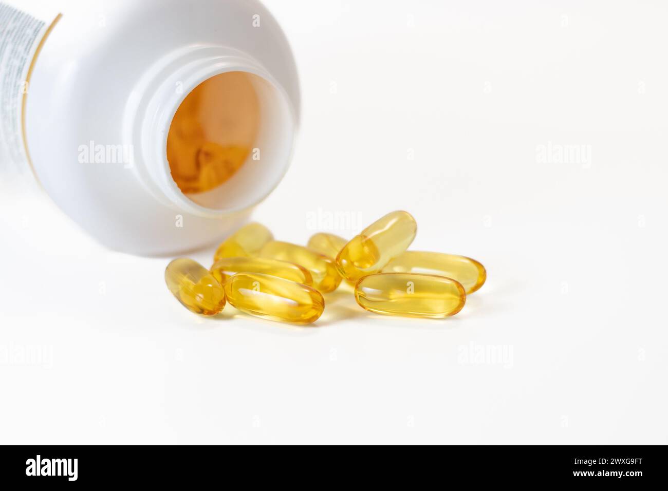 Yellow fish oil capsules in a jelly shell near the white jar Stock ...