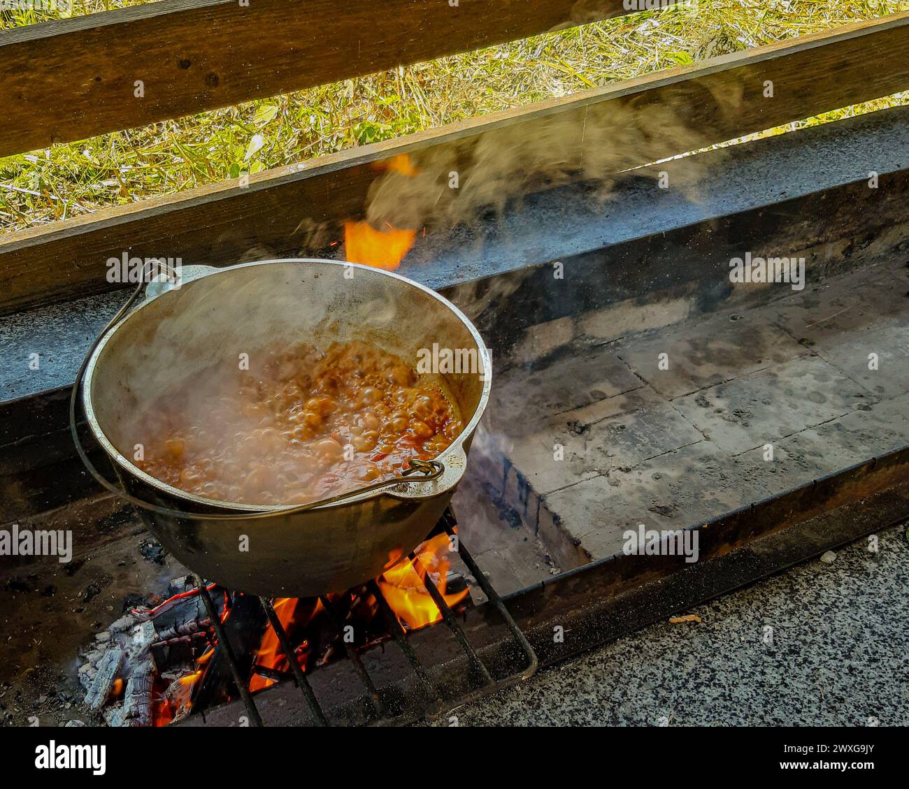 Cooking food in cauldron on open fire Stock Photo - Alamy