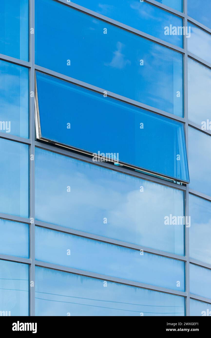 Blue glass reflects cloudy sky modern building facade exterior office ...
