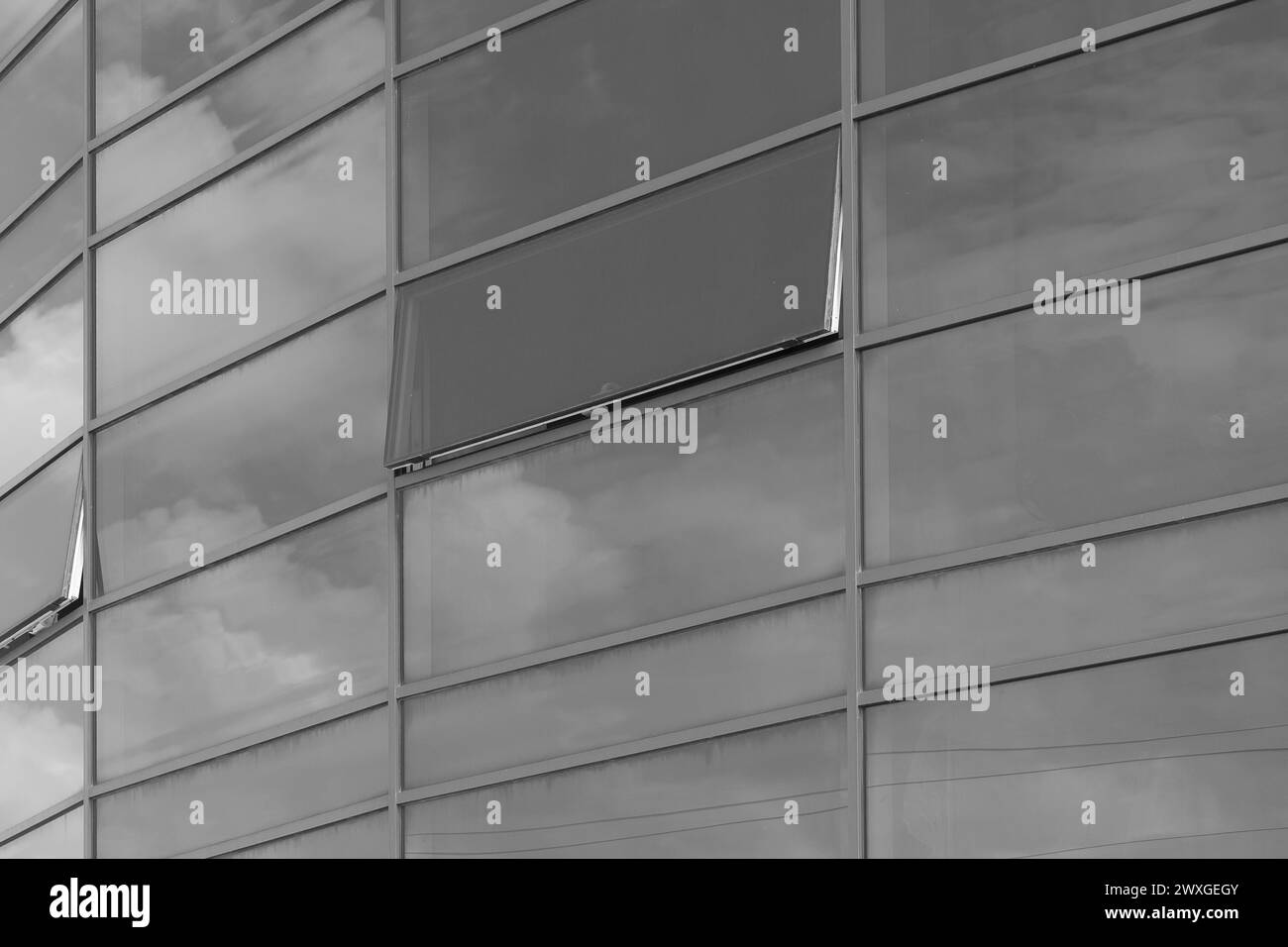 Dark grey glass reflects cloudy sky modern building facade exterior ...
