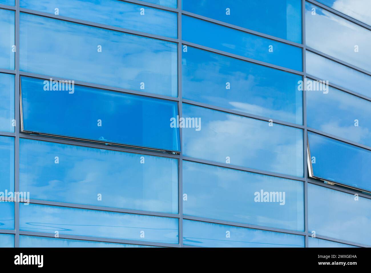 Blue glass reflects cloudy sky modern building facade exterior office ...